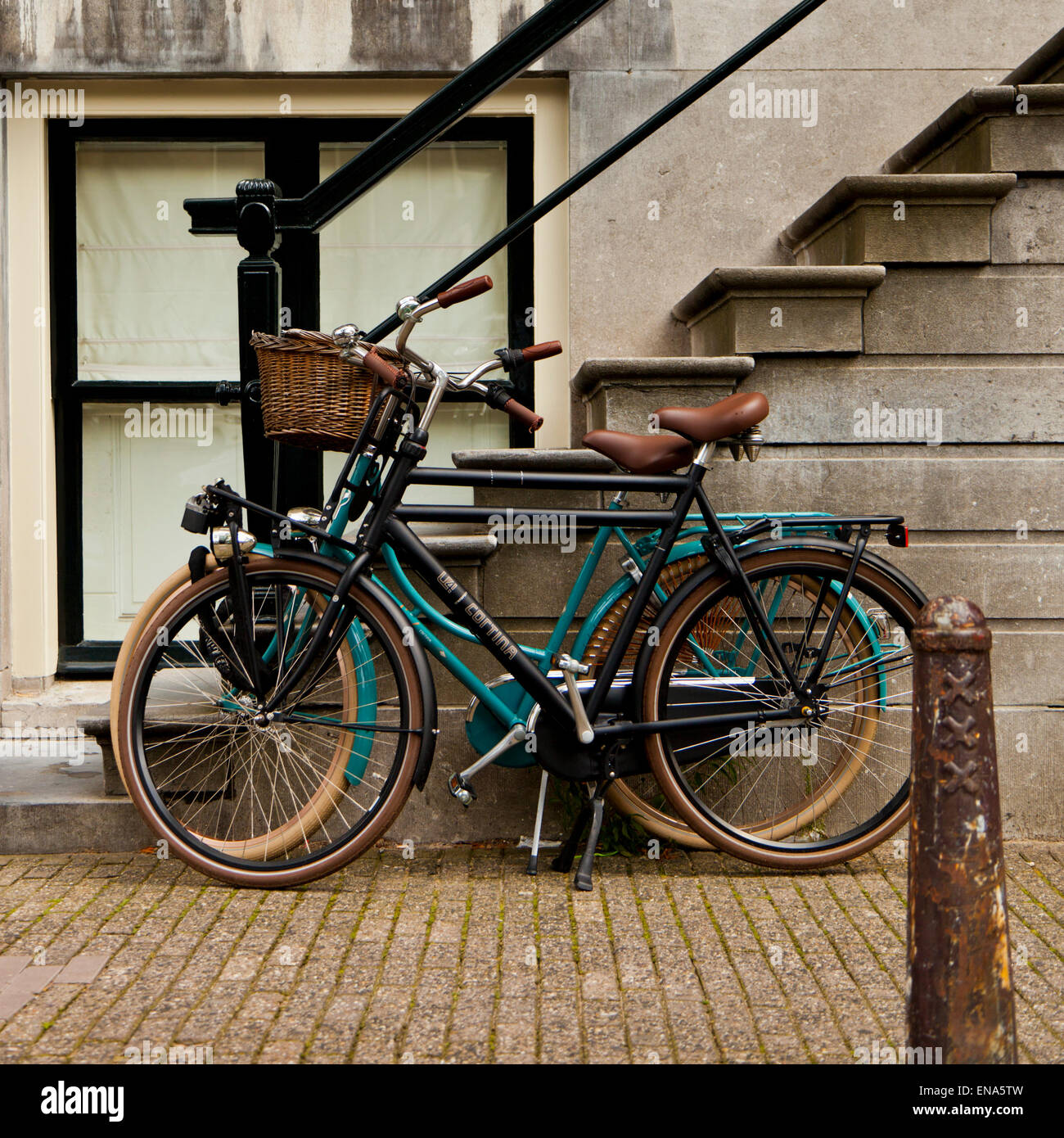 Two bikes chained to railings at the foot of some steps in Amsterdam ...