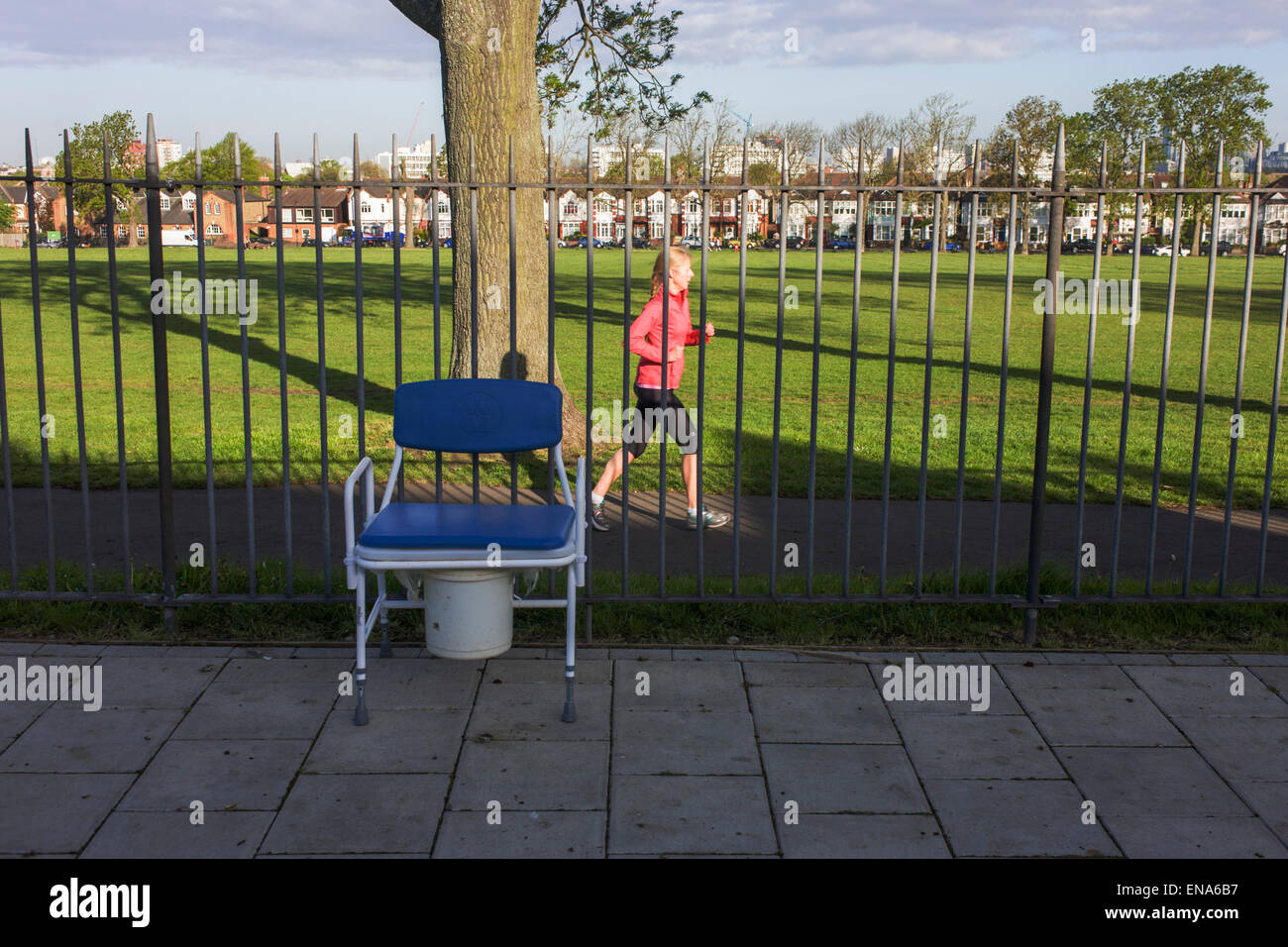 A jogger runs past a dumped commode by the railings of a south London ...