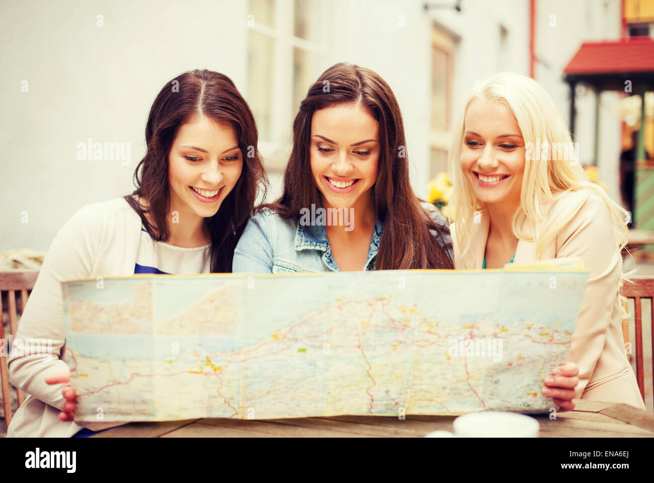 beautiful girls looking into tourist map in city Stock Photo - Alamy