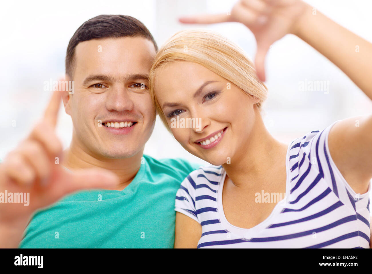 smiling happy couple making frame gesture at home Stock Photo - Alamy