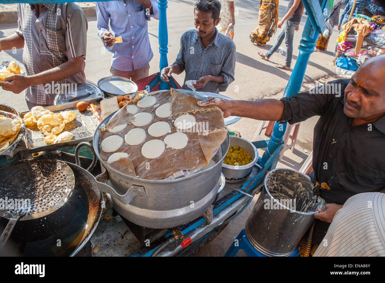 Man preparing and making idlis at a food stall in the street in ...