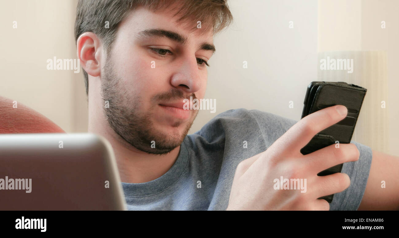 Man using cellphone home young hi-res stock photography and images - Alamy