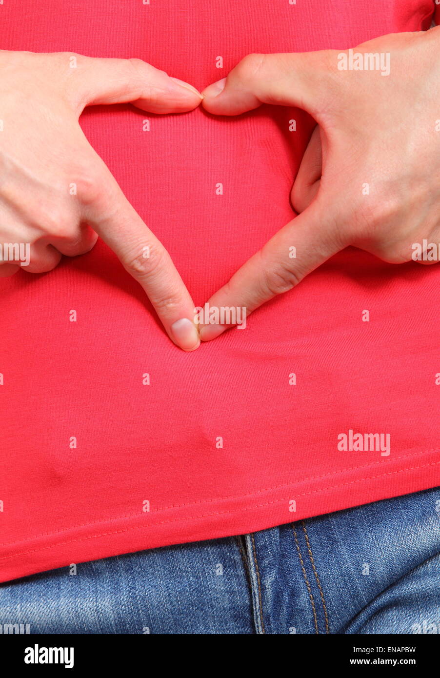 Heart shape with hands of woman and man over belly, symbol of love ...