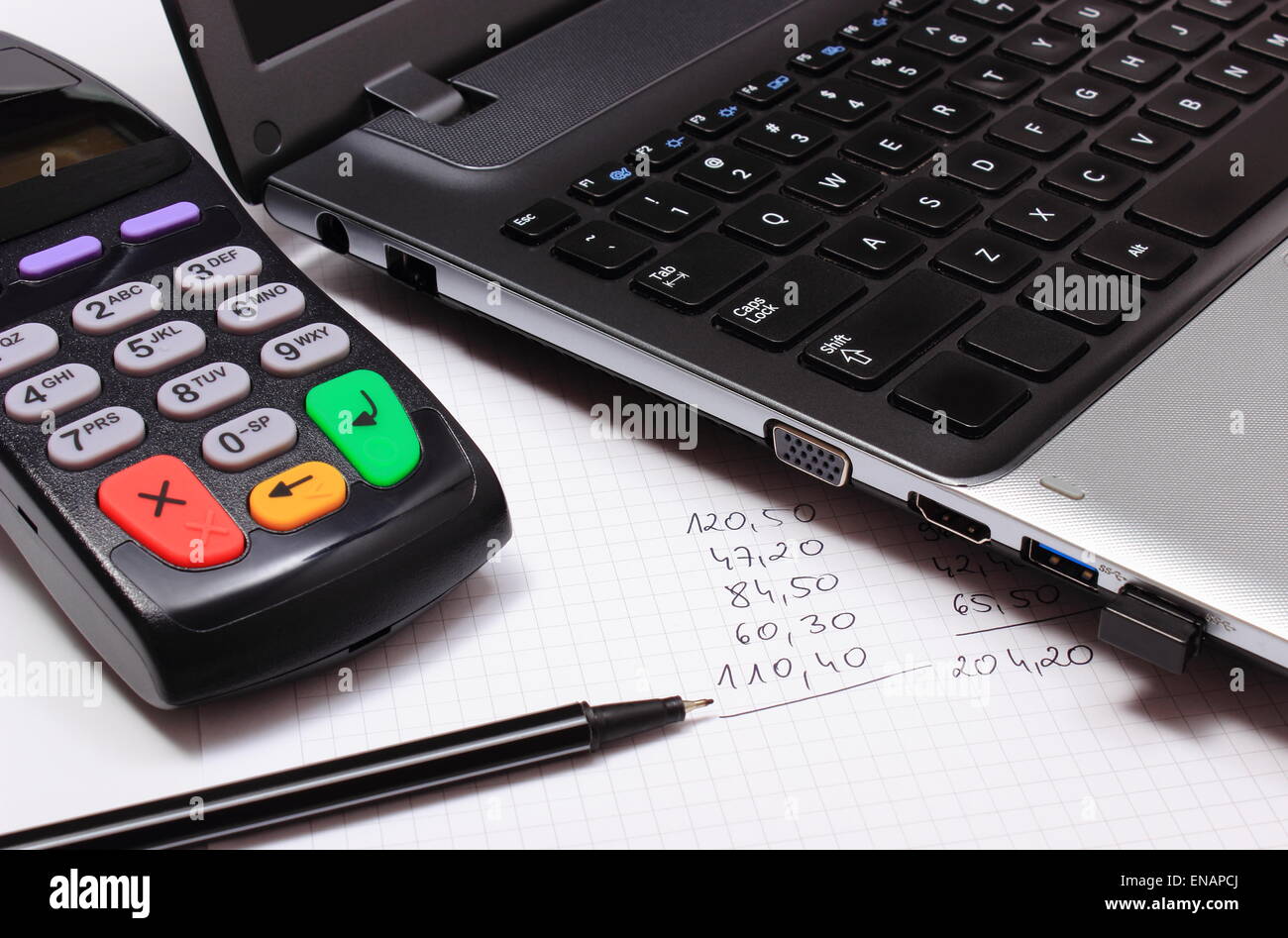 Payment terminal with laptop and financial calculations, credit card ...