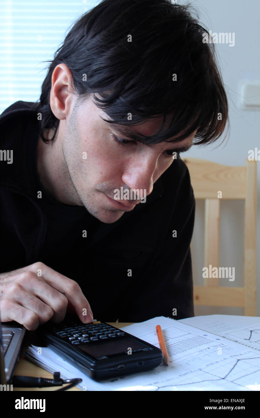 Man studying and making calculations with computer and calculator Stock ...