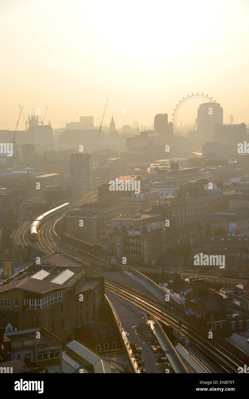 London skyline at dusk, the London Eye silhouetted and a train to ...