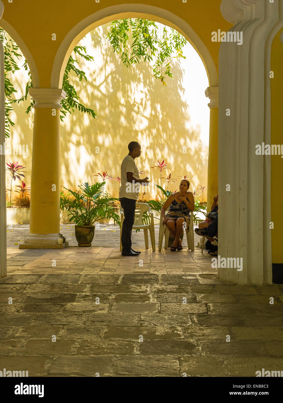 A Cuban man waits on guests in lobby of a building in Havana Vieja ...
