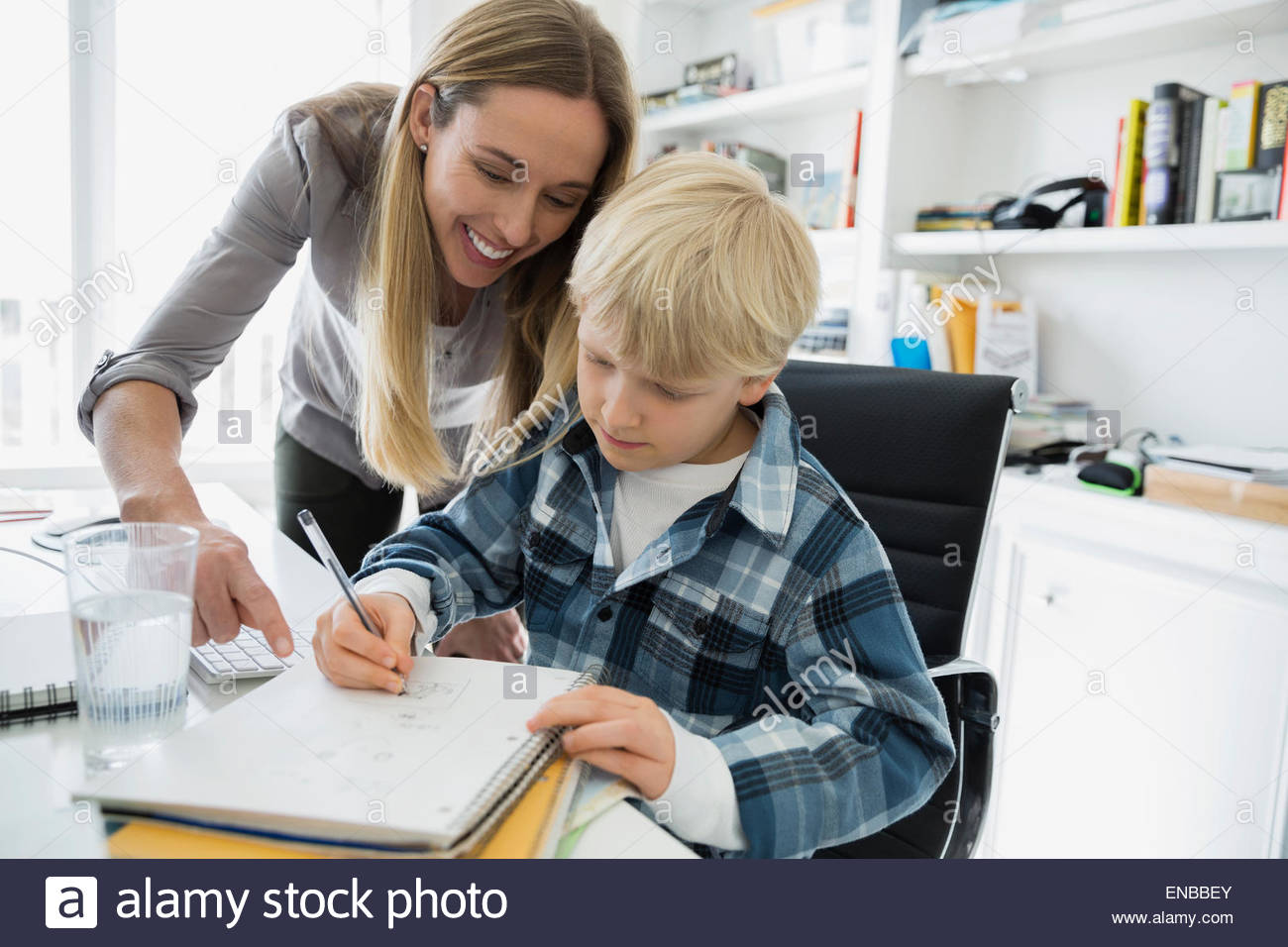 Mother helping son with homework in home office Stock Photo - Alamy