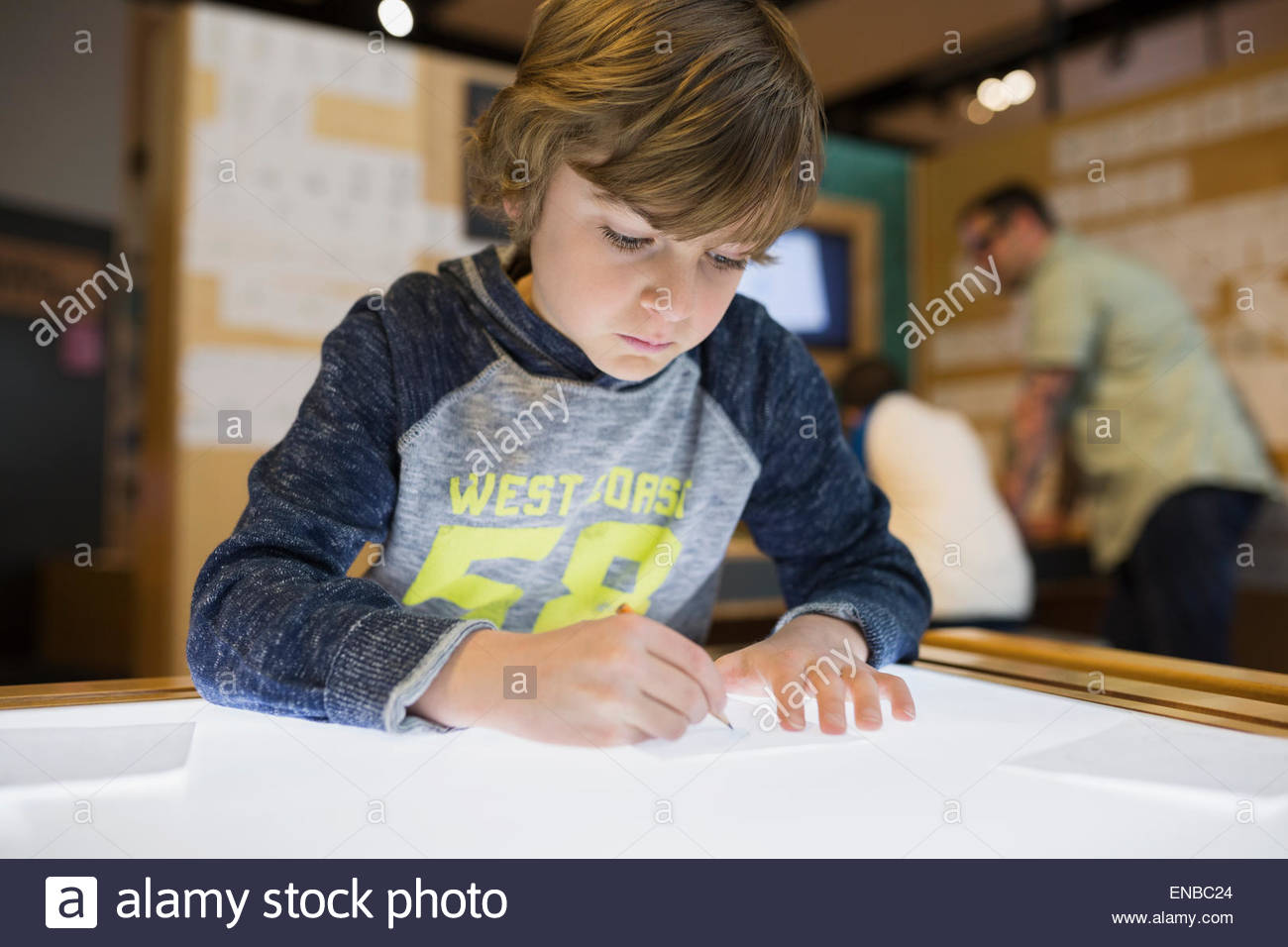 Boy tracing on light table at science center Stock Photo - Alamy