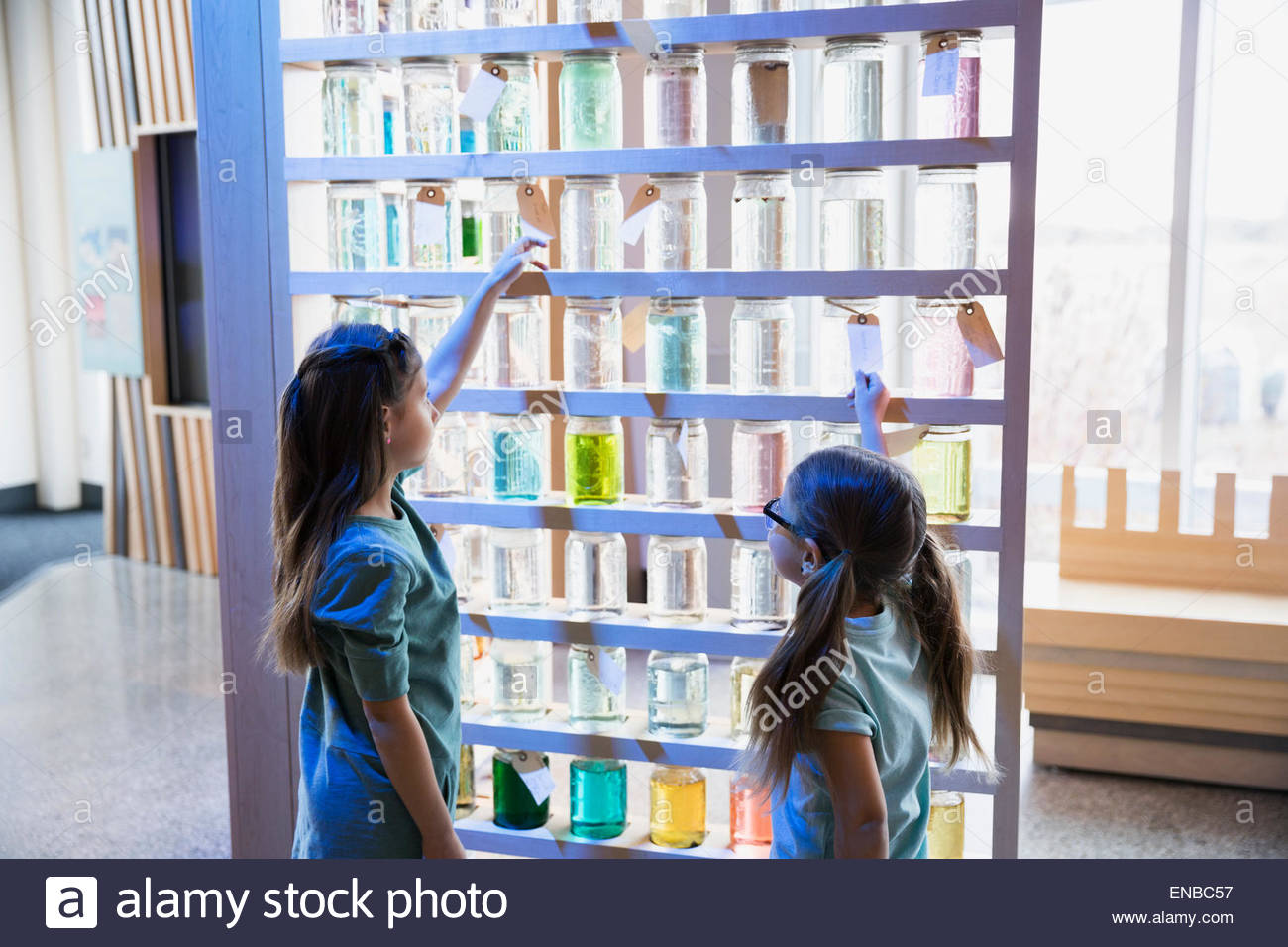Sisters viewing jar display at science center Stock Photo - Alamy