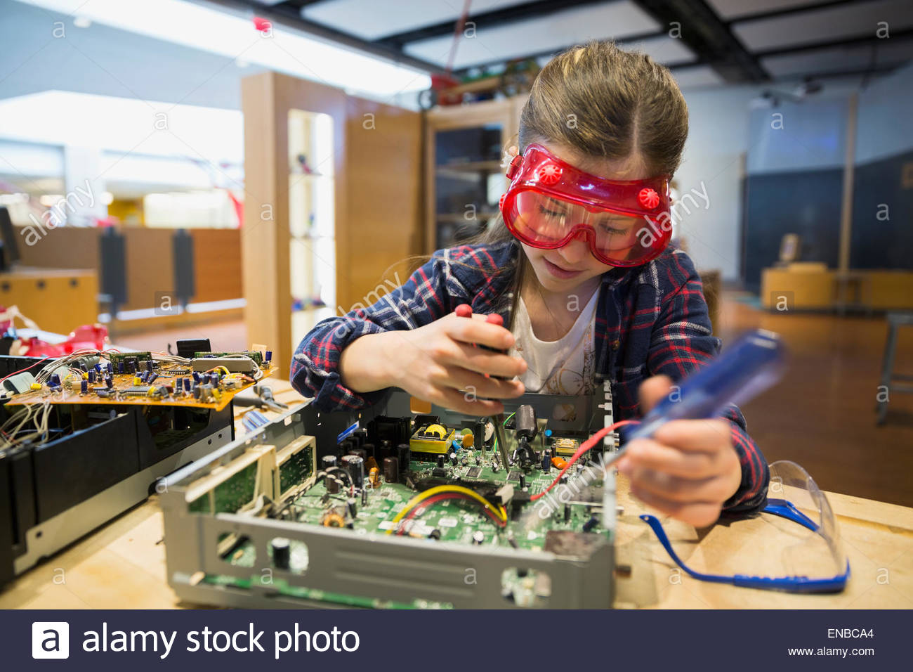 Girl goggles assembling electronics circuit at science center Stock ...