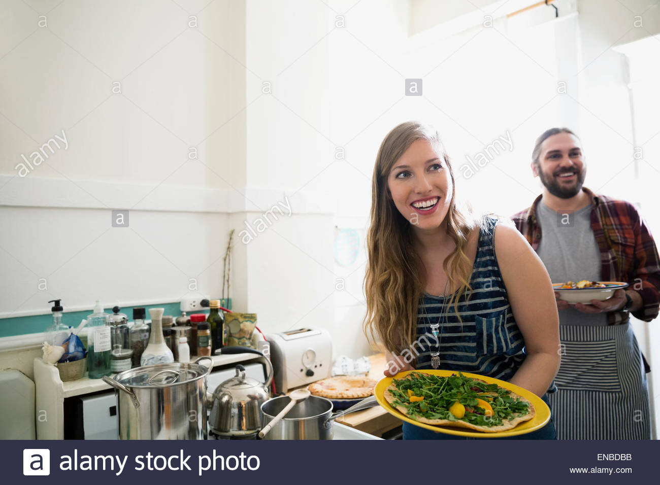 Couple cooking and preparing to serve food kitchen Stock Photo - Alamy