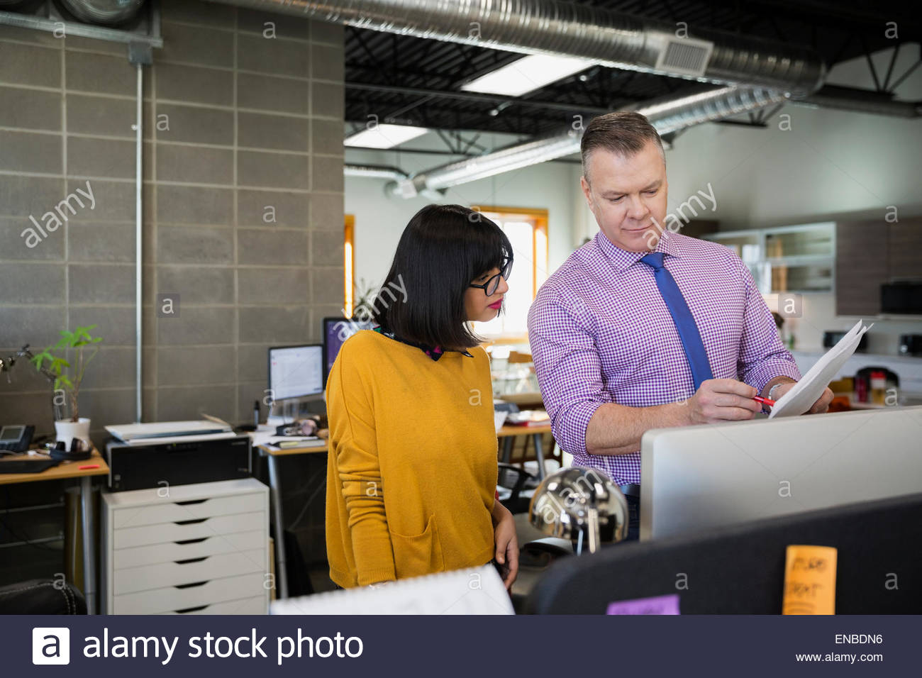 Business people reviewing paperwork in office Stock Photo - Alamy