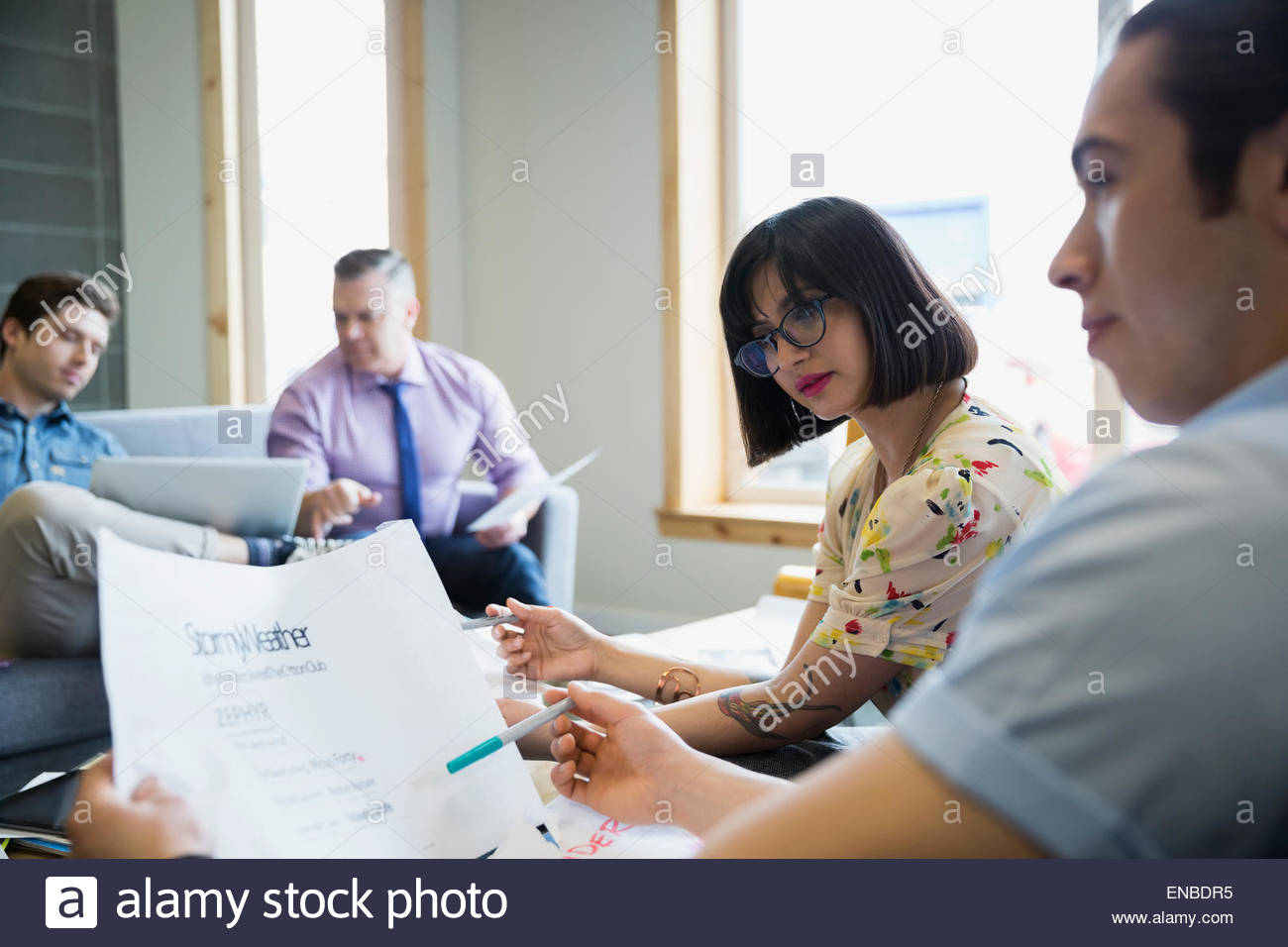 Business people reviewing paperwork, in meeting Stock Photo - Alamy