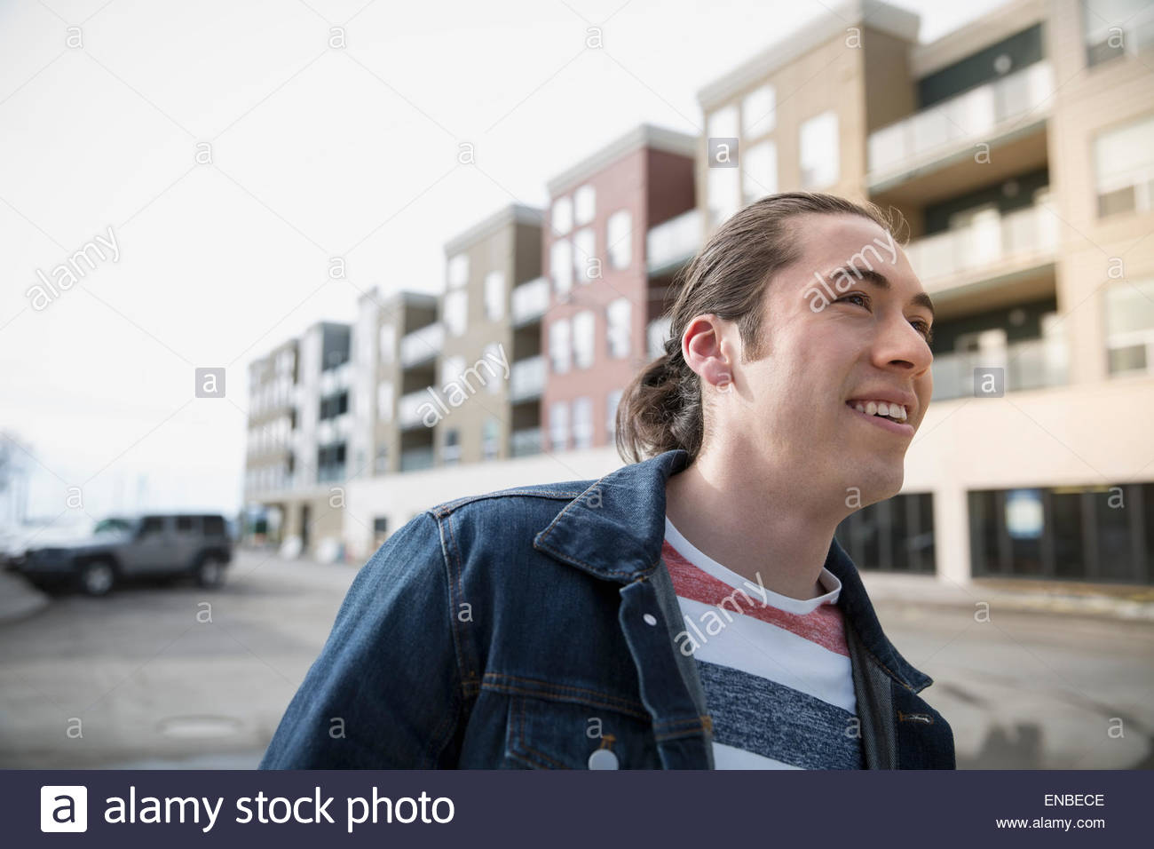 Smiling man looking away on urban street Stock Photo - Alamy