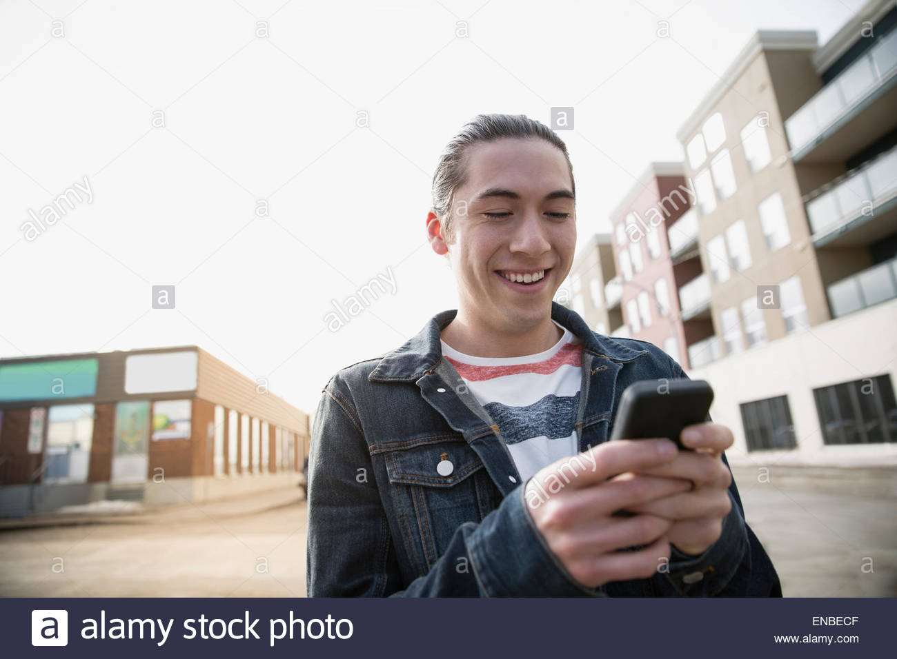 Smiling man texting on urban street Stock Photo - Alamy