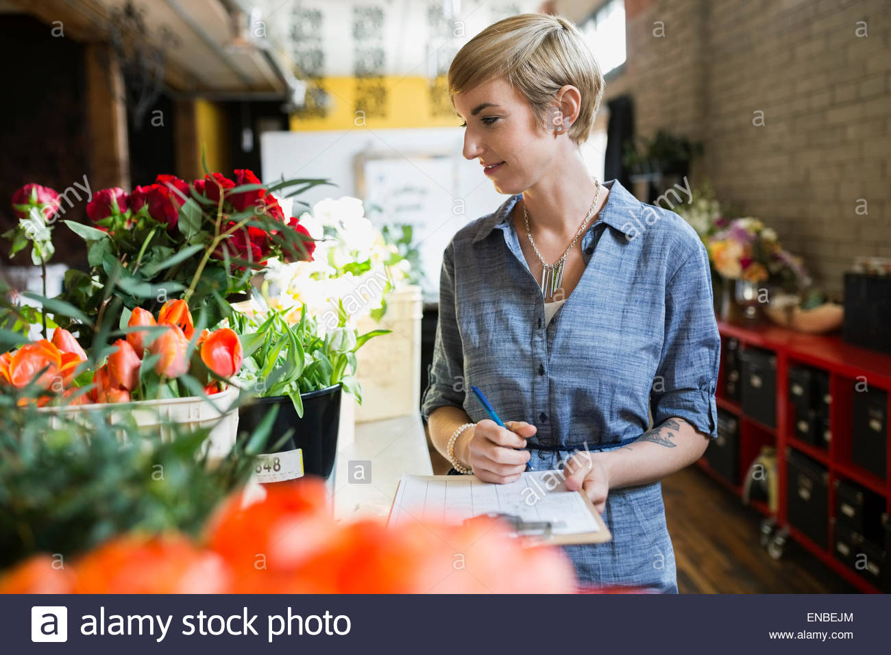 Florist with clipboard checking flower inventory flower shop Stock ...