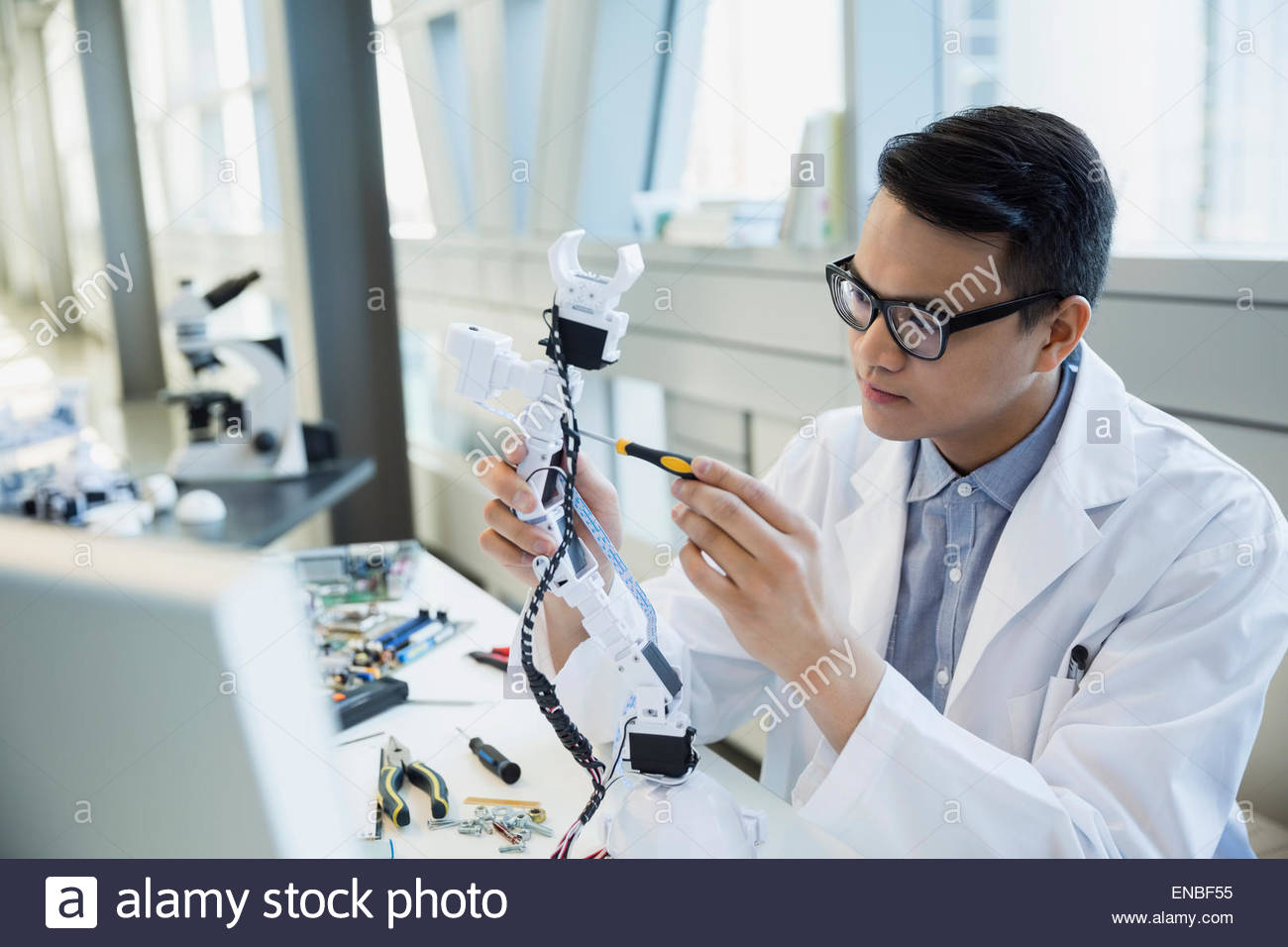 Focused engineer in lab coat assembling robotic arm Stock Photo - Alamy Focused engineer in lab coat assembling robotic arm Stock Photo - Alamy