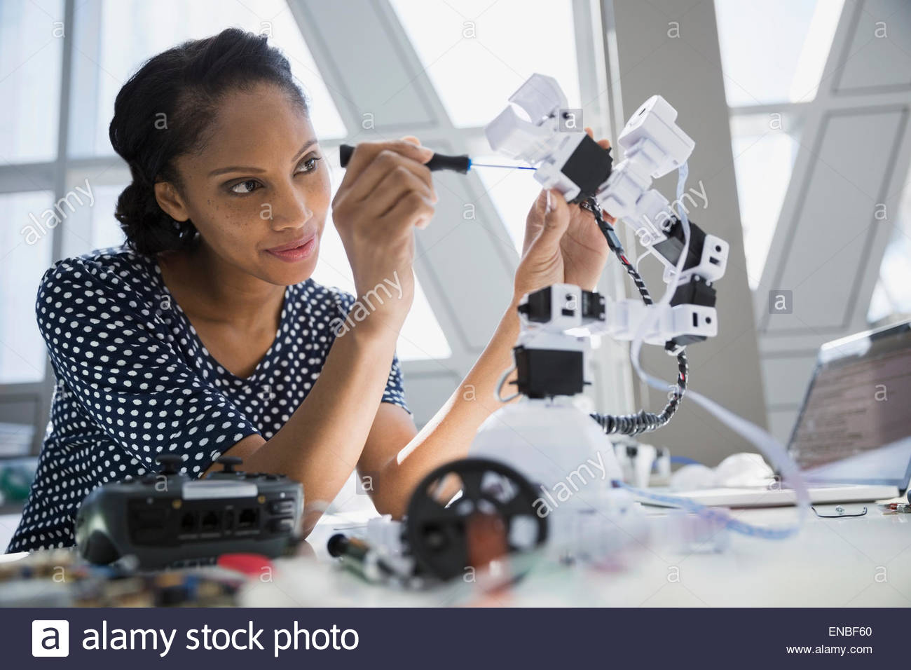 Engineer assembling robotic arm at desk Stock Photo - Alamy
