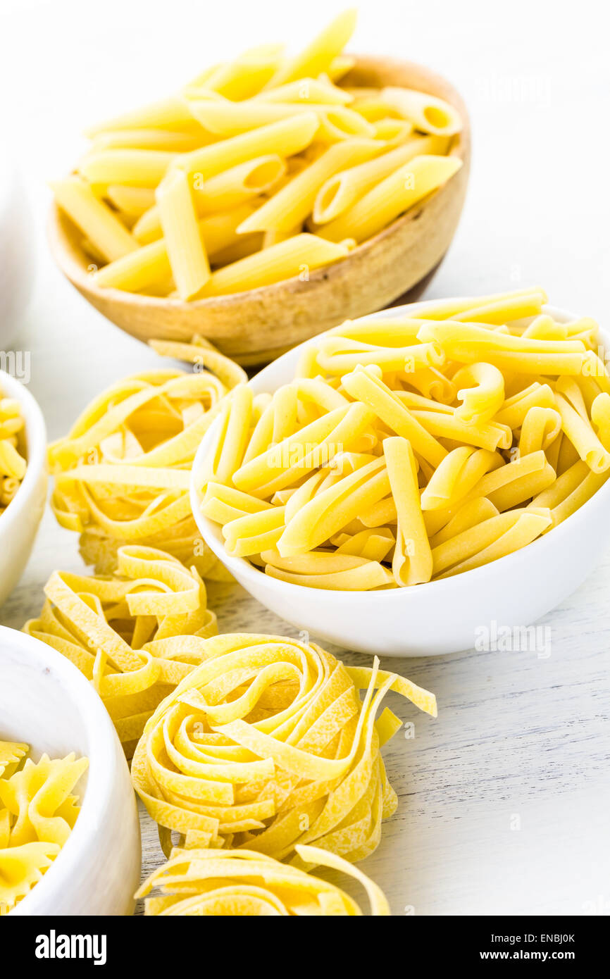 Variety of yellow dry pasta in small round bowls Stock Photo - Alamy