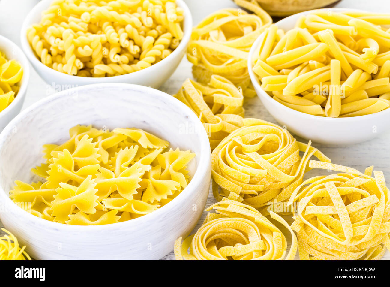 Variety of yellow dry pasta in small round bowls Stock Photo - Alamy