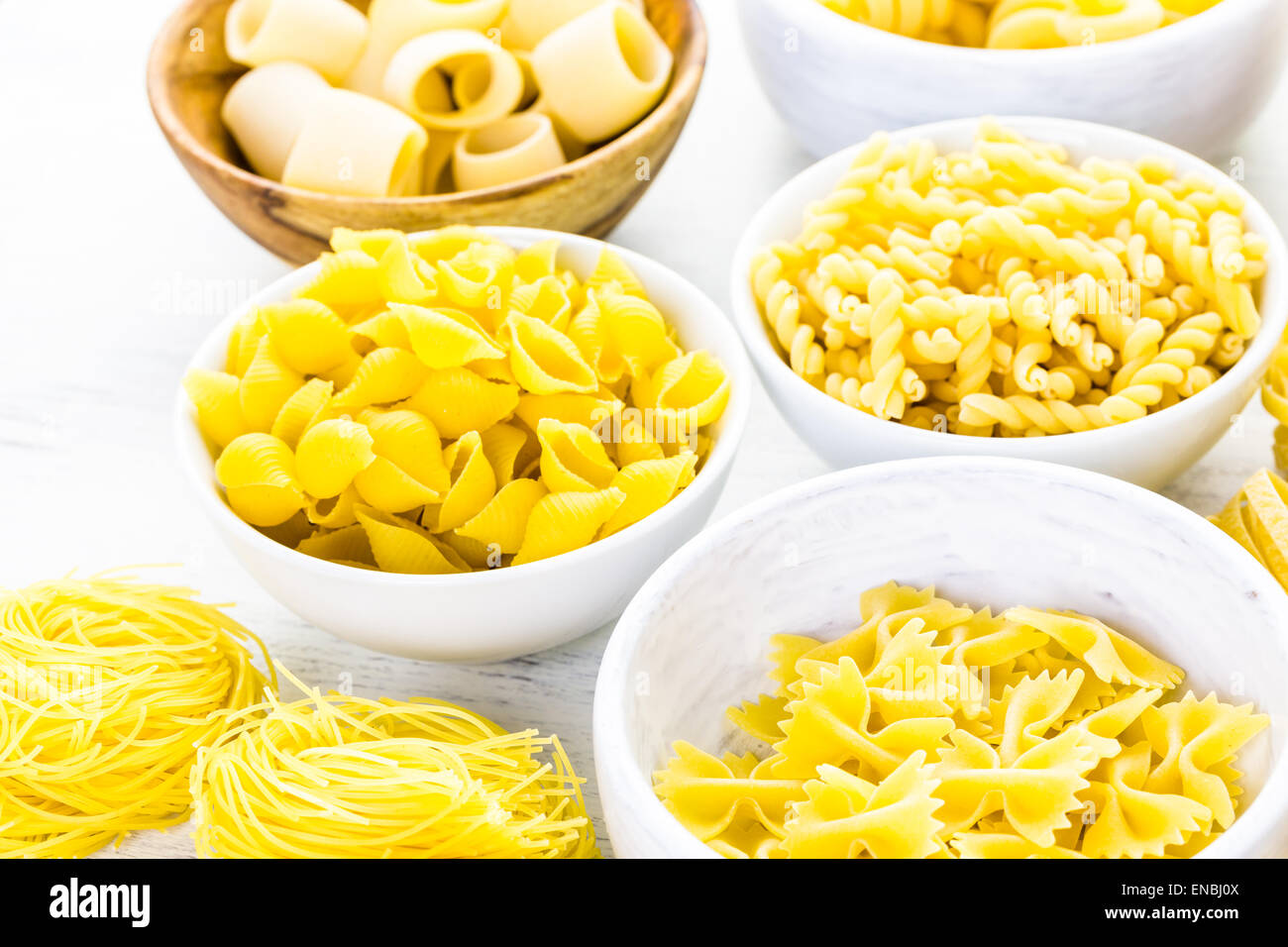 Variety of yellow dry pasta in small round bowls Stock Photo - Alamy