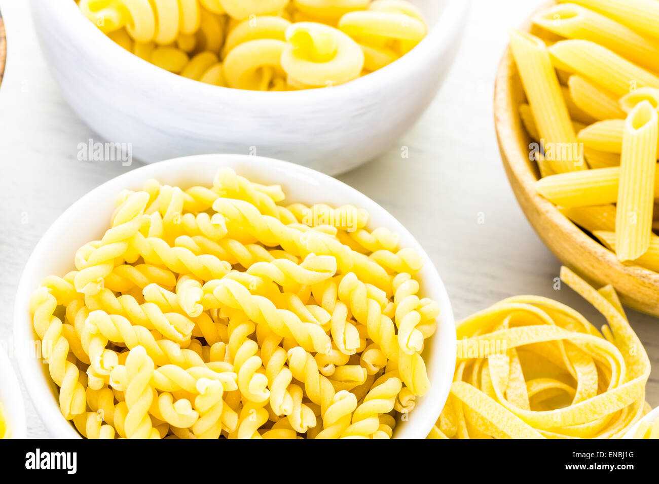 Variety of yellow dry pasta in small round bowls Stock Photo - Alamy