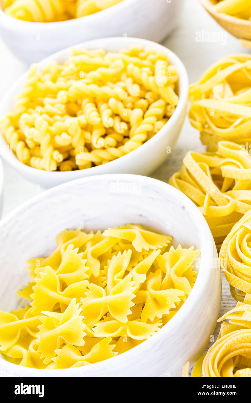 Variety of yellow dry pasta in small round bowls Stock Photo - Alamy