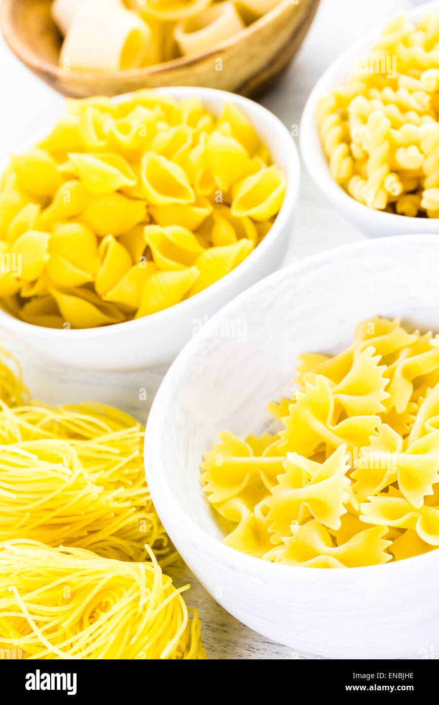 Variety of yellow dry pasta in small round bowls Stock Photo - Alamy