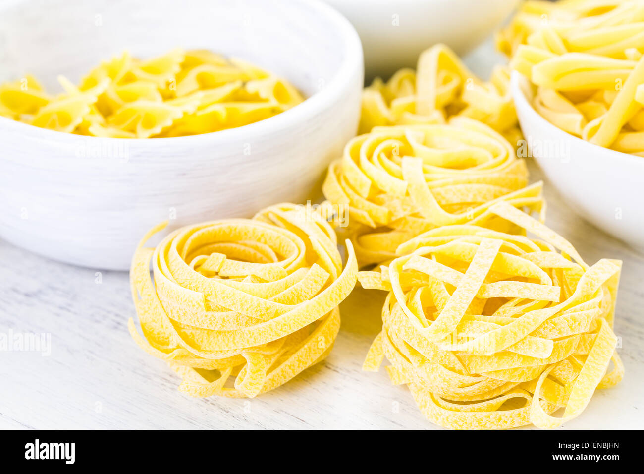 Variety of yellow dry pasta in small round bowls Stock Photo - Alamy