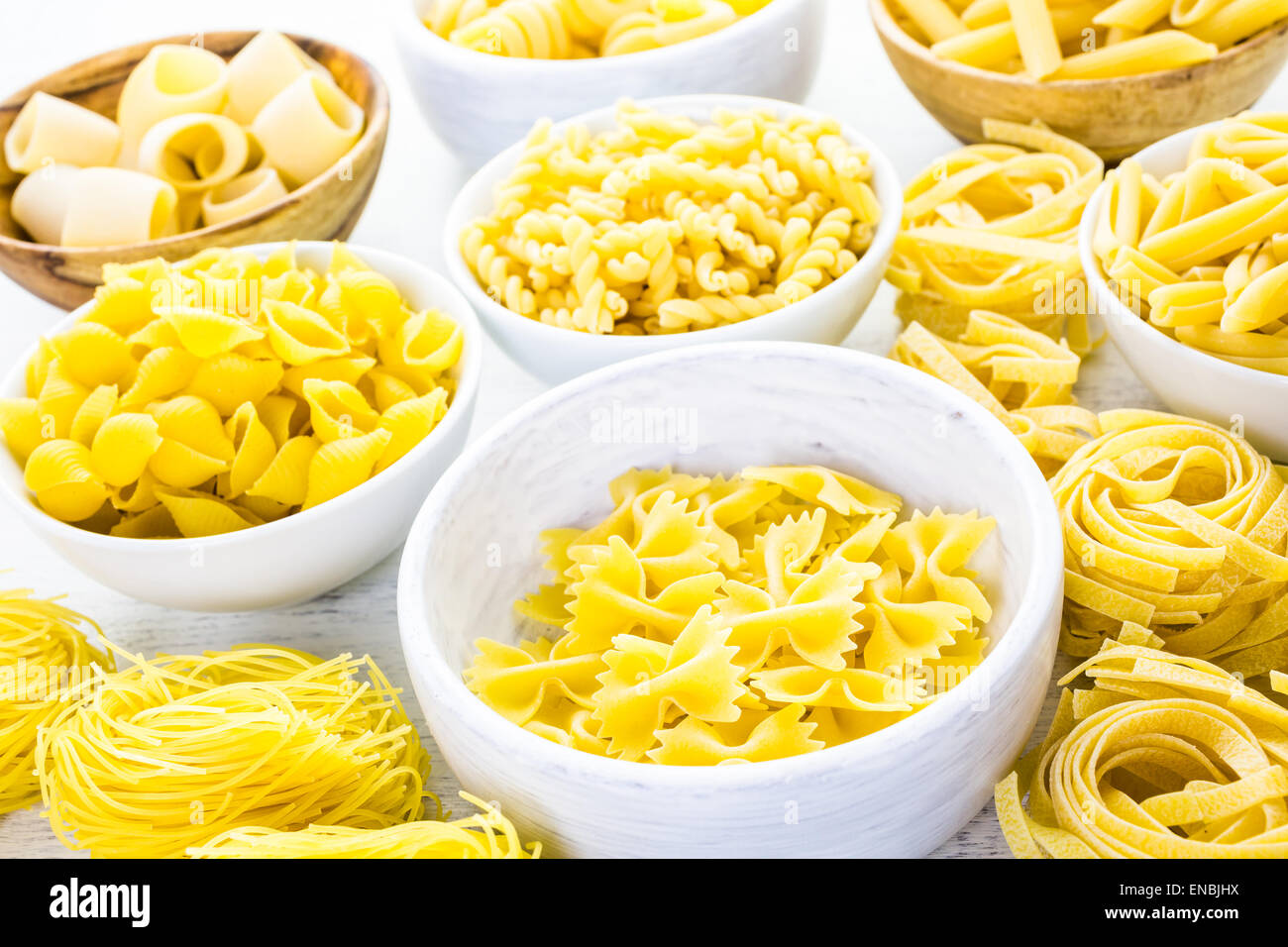 Variety of yellow dry pasta in small round bowls Stock Photo - Alamy