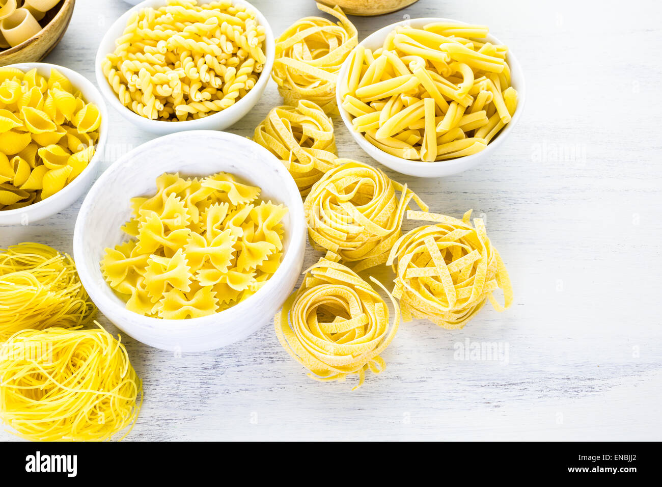 Variety of yellow dry pasta in small round bowls Stock Photo - Alamy