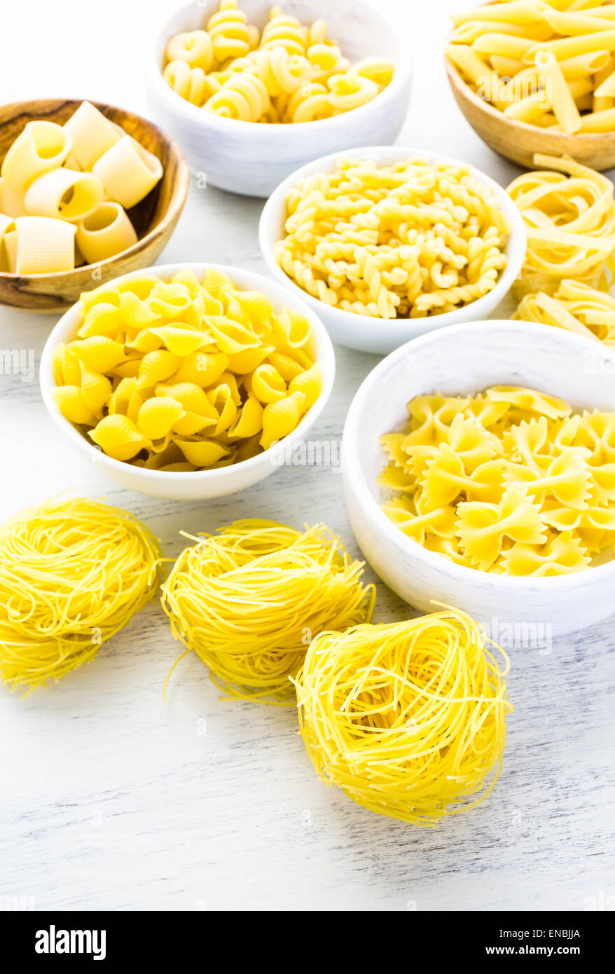 Variety of yellow dry pasta in small round bowls Stock Photo - Alamy