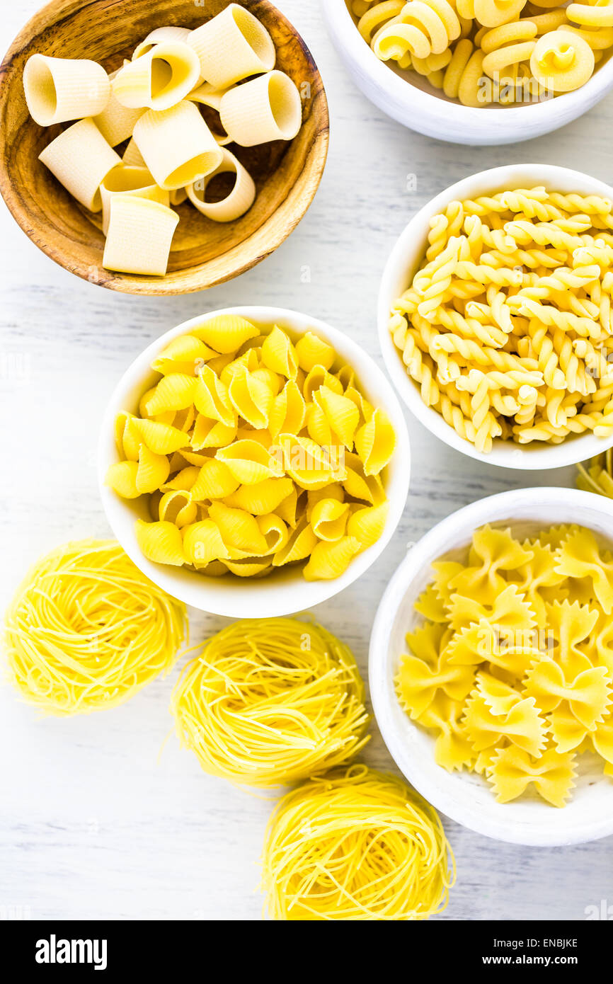 Variety of yellow dry pasta in small round bowls Stock Photo - Alamy