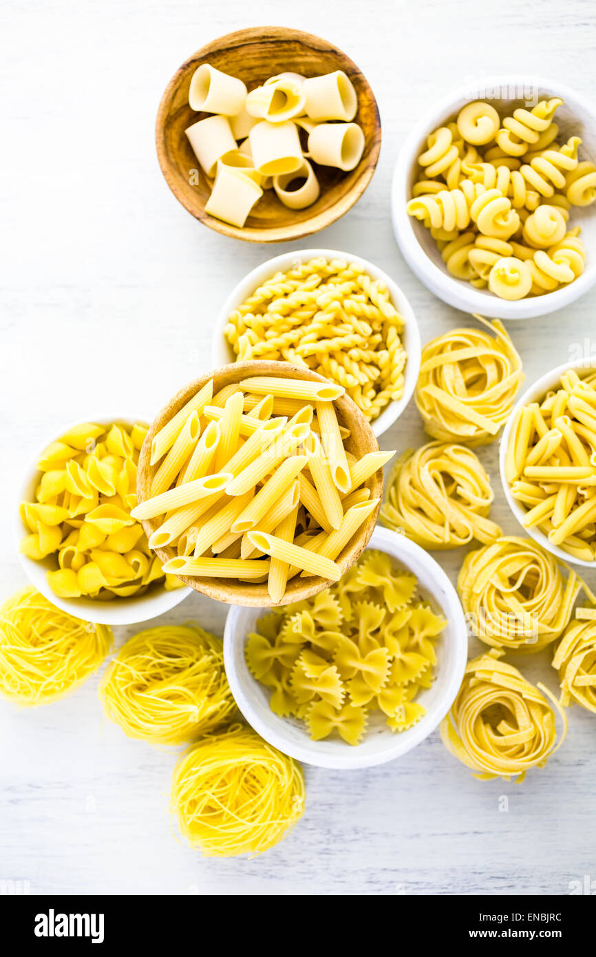 Variety of yellow dry pasta in small round bowls Stock Photo - Alamy