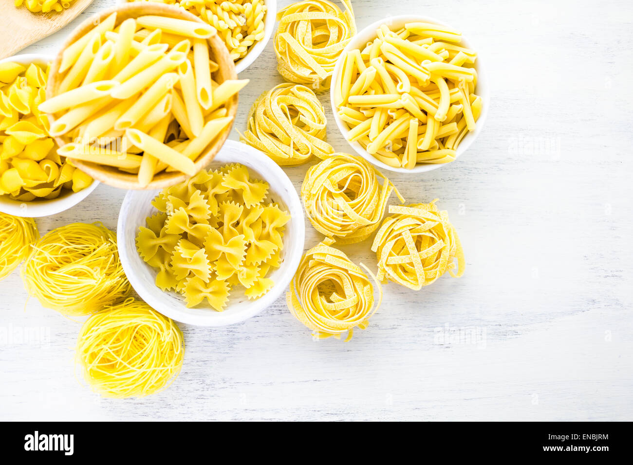 Variety of yellow dry pasta in small round bowls Stock Photo - Alamy