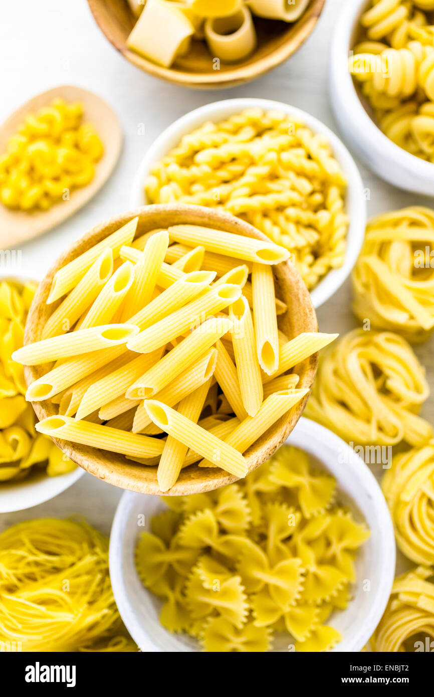 Variety of yellow dry pasta in small round bowls Stock Photo - Alamy
