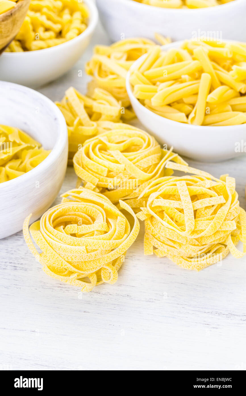 Variety of yellow dry pasta in small round bowls Stock Photo - Alamy