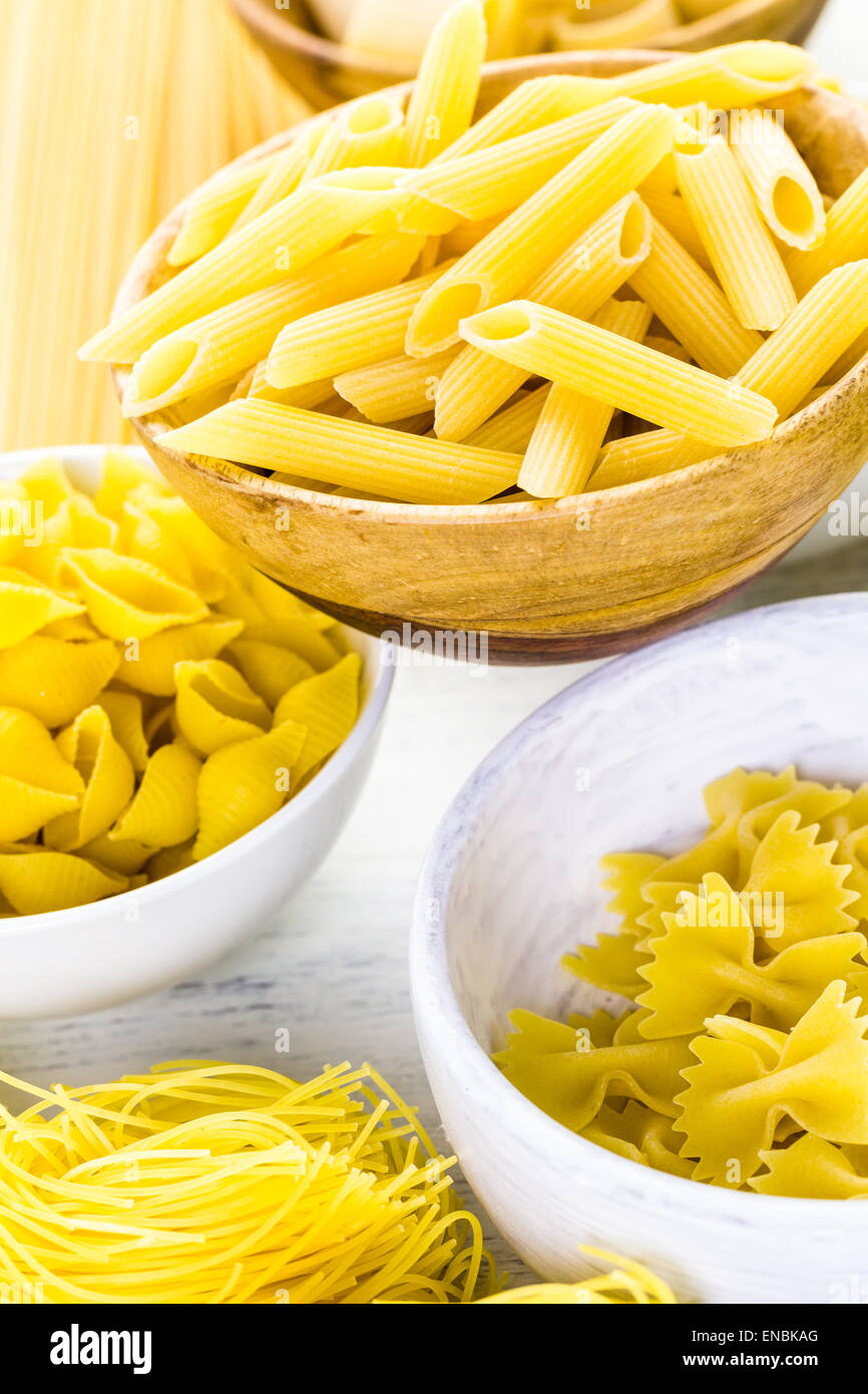 Variety of yellow dry pasta in small round bowls Stock Photo - Alamy