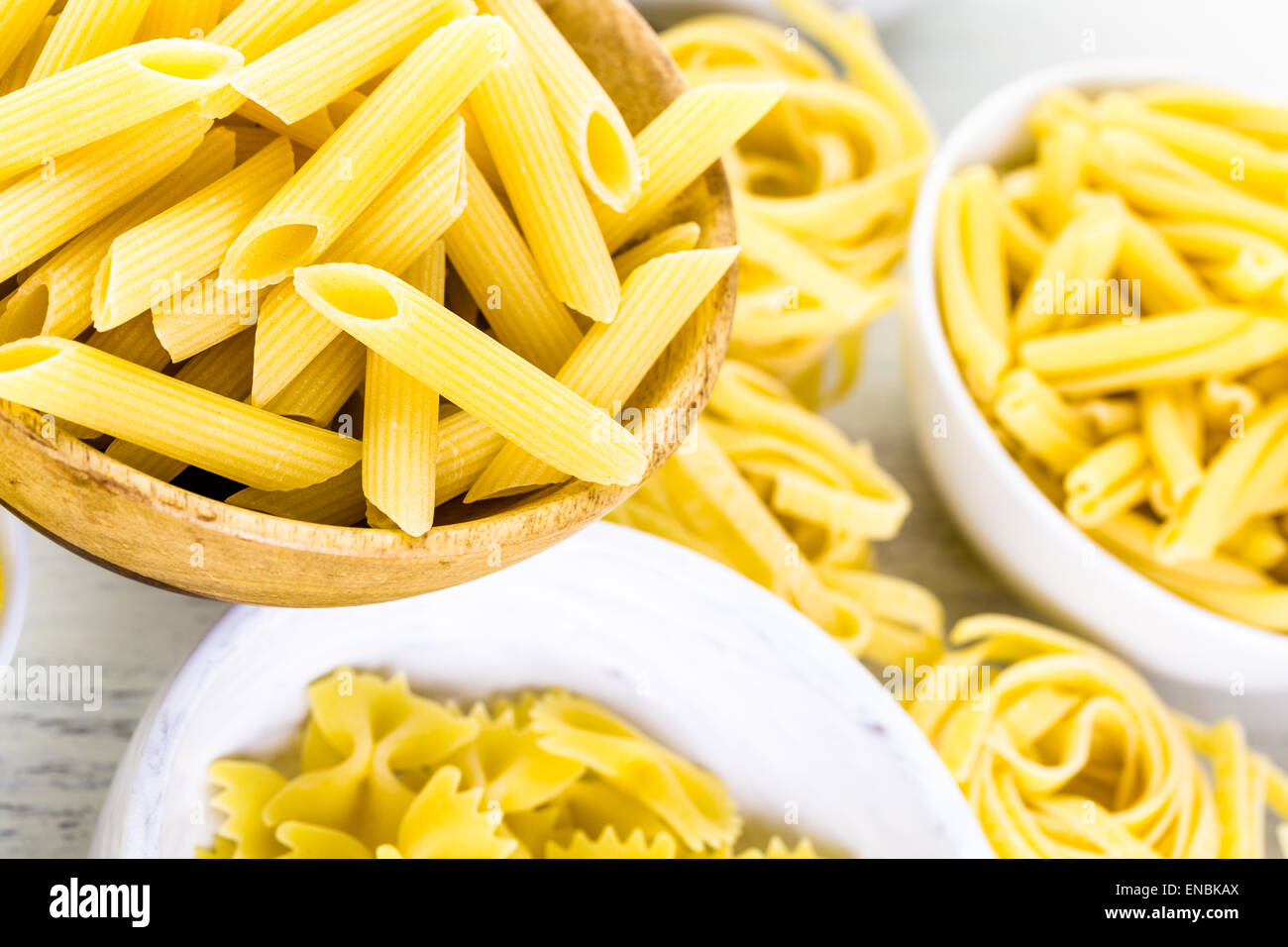 Variety of yellow dry pasta in small round bowls Stock Photo - Alamy