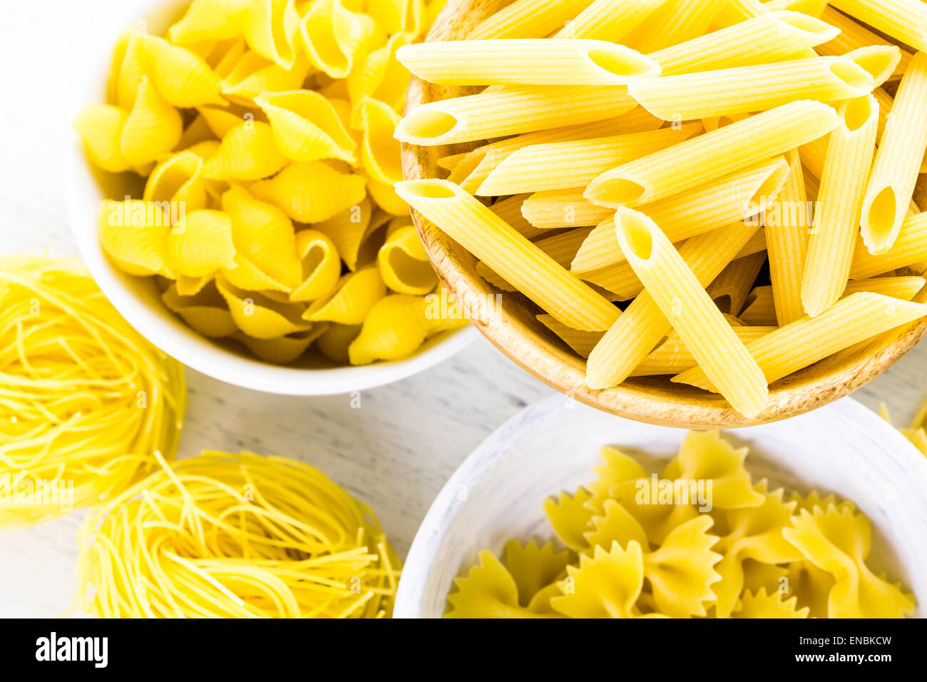 Variety of yellow dry pasta in small round bowls Stock Photo - Alamy