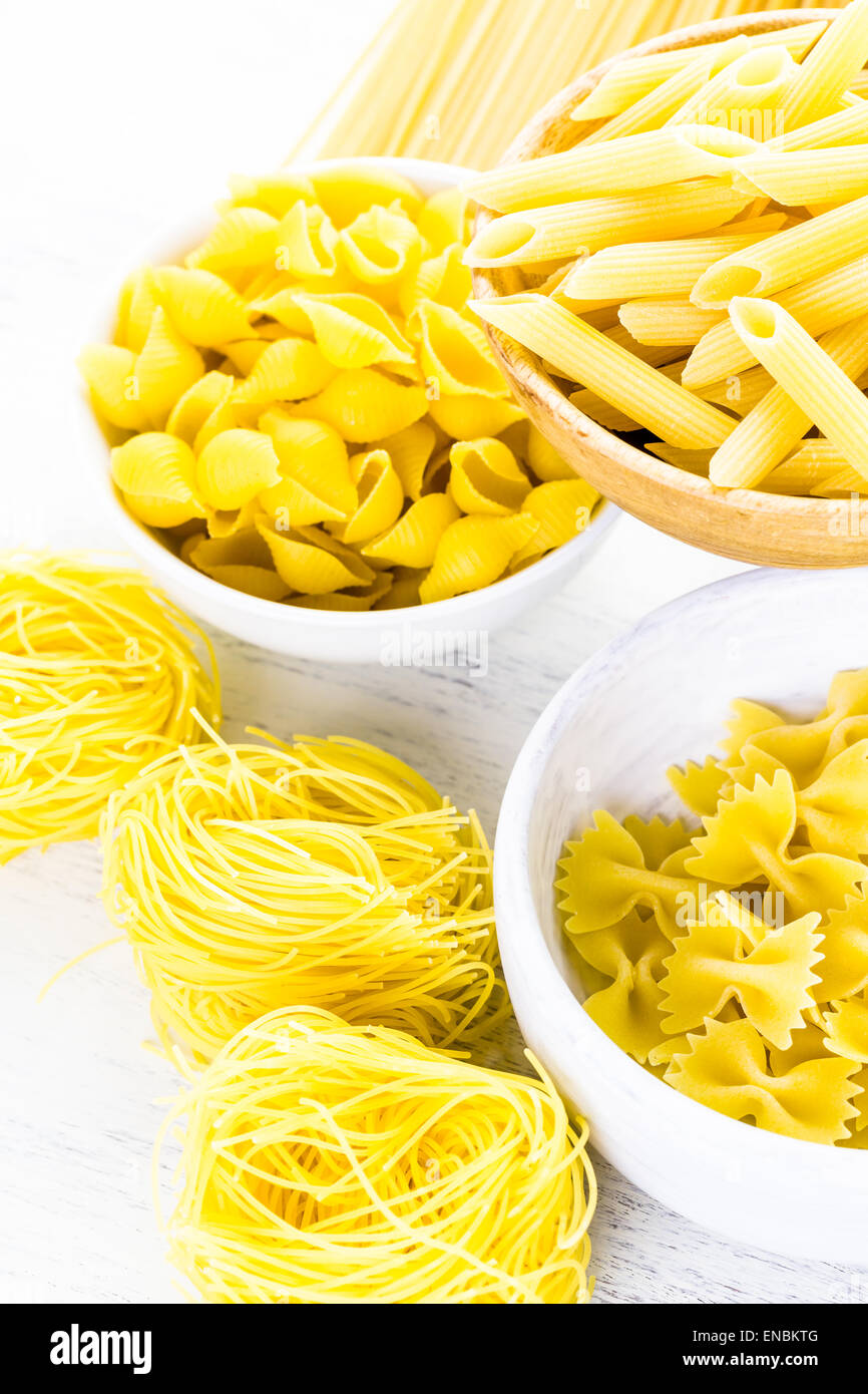 Variety of yellow dry pasta in small round bowls Stock Photo - Alamy