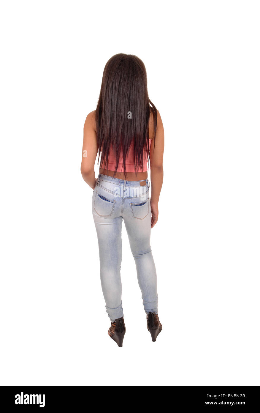 A young pretty woman standing from the back with her long brunette hair ...