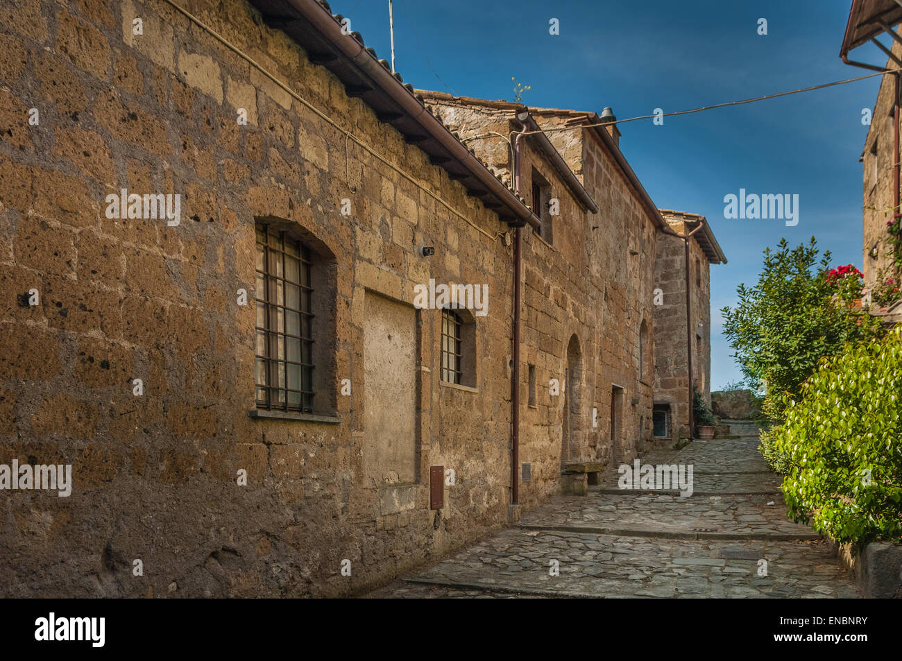 Brick stonework buildings with cobblestone alleyway in Civita di ...