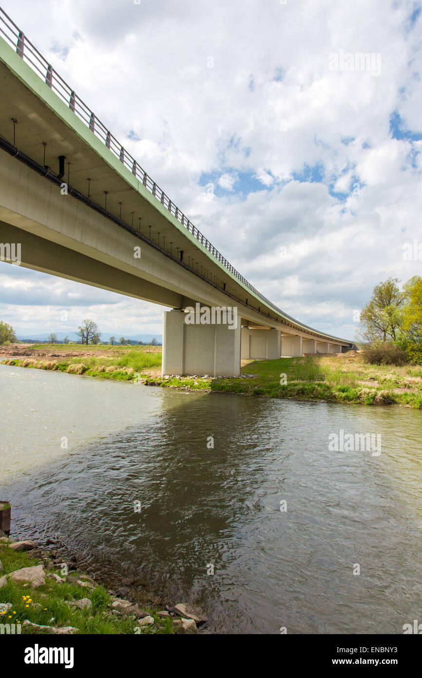 Modern long bridge over the small river Stock Photo - Alamy