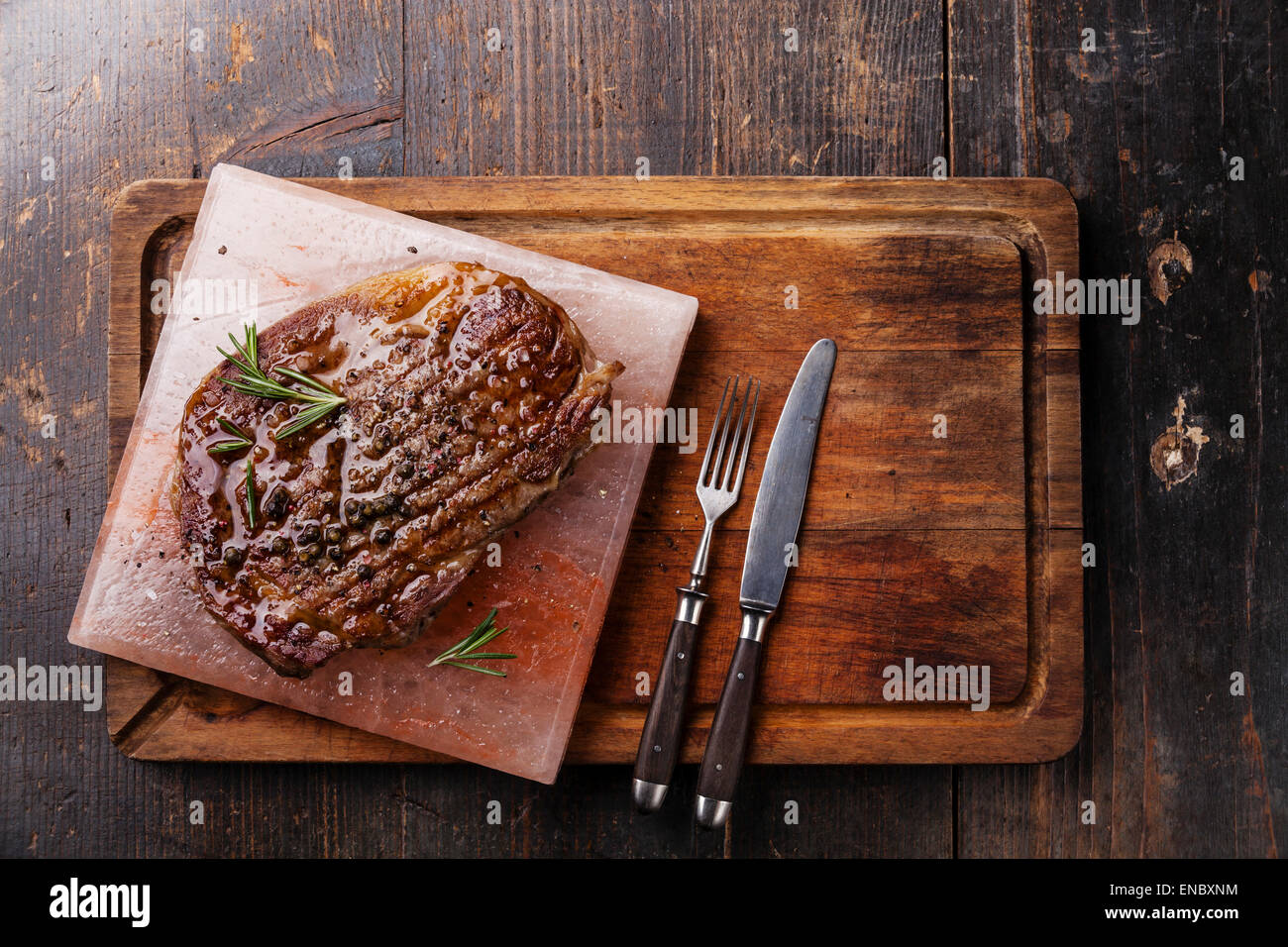 Grilled Black Angus Steak Ribeye on Himalayan pink salt block on dark ...