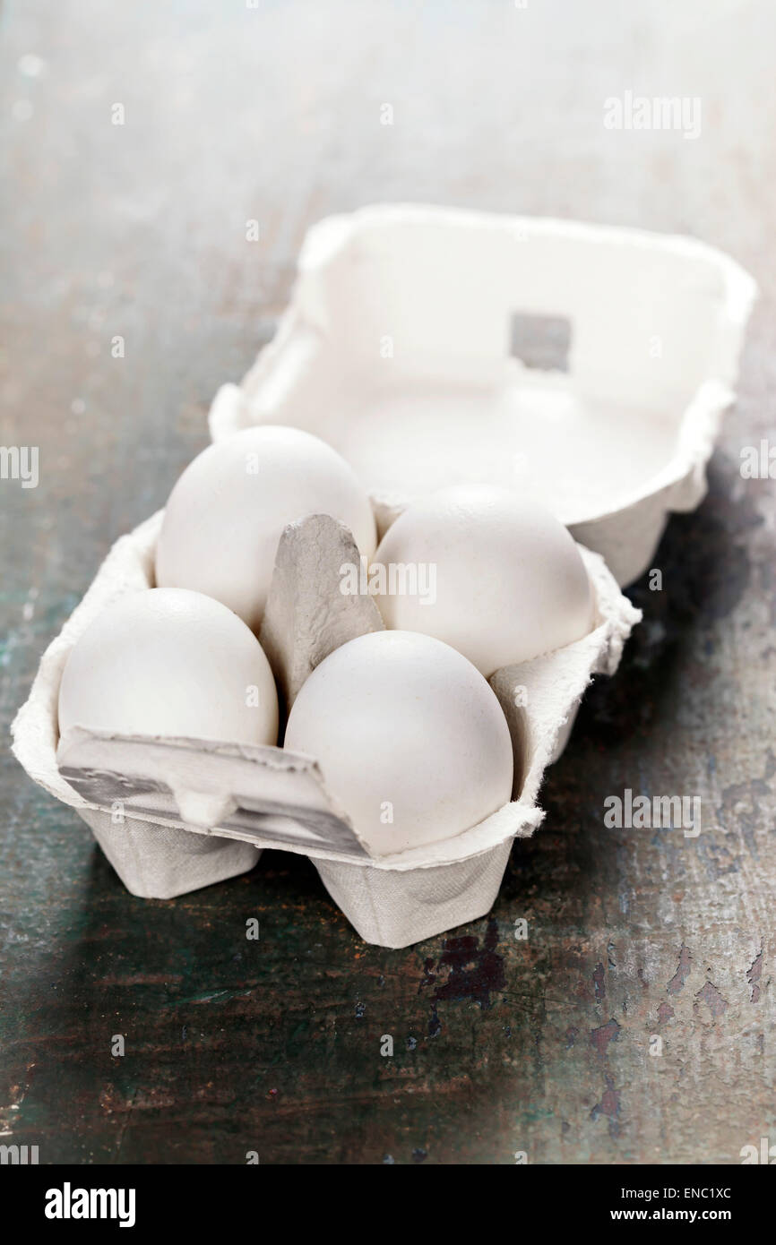 Cardboard egg box with eggs on wooden table Stock Photo - Alamy