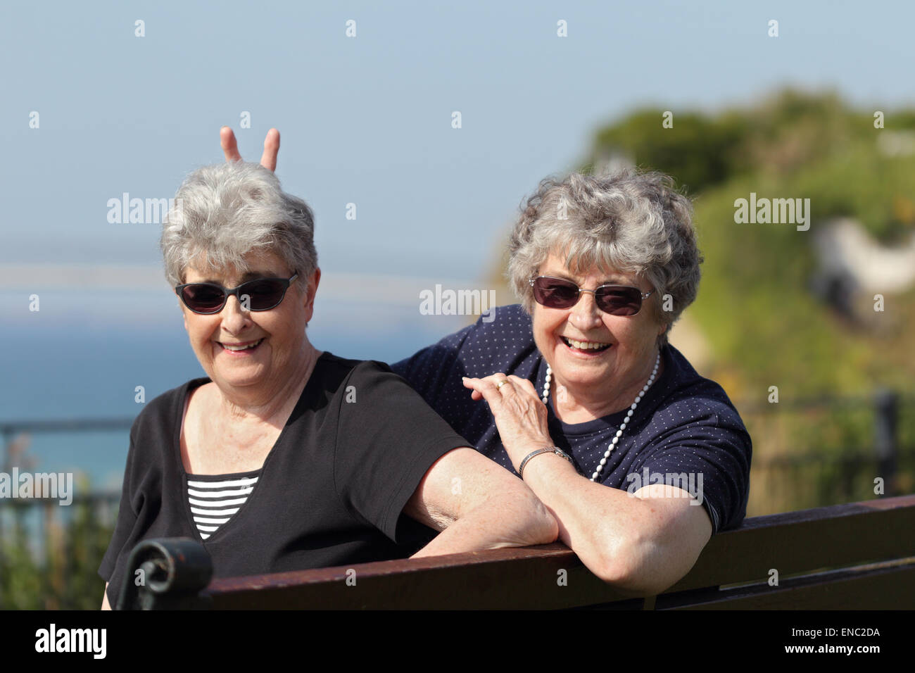 Playful elderly twin sisters on holiday by the ocean Stock Photo - Alamy