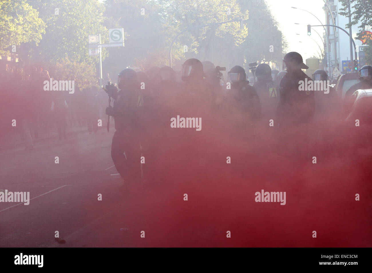 Hamburg, Germany. 1st May, 2015. Red smoke flares cover a troop op riot ...