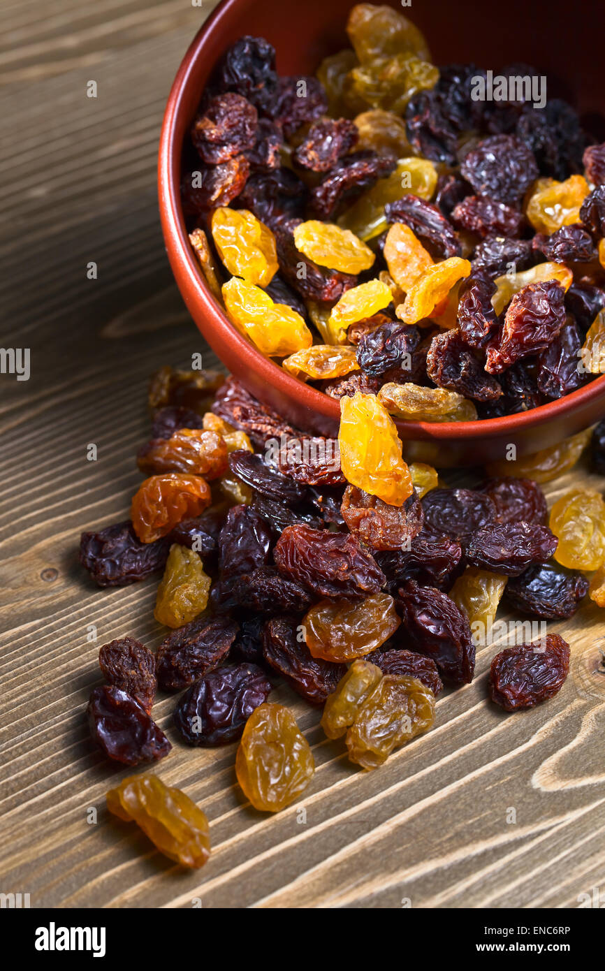 raisins in a brown dish on wooden table Stock Photo - Alamy